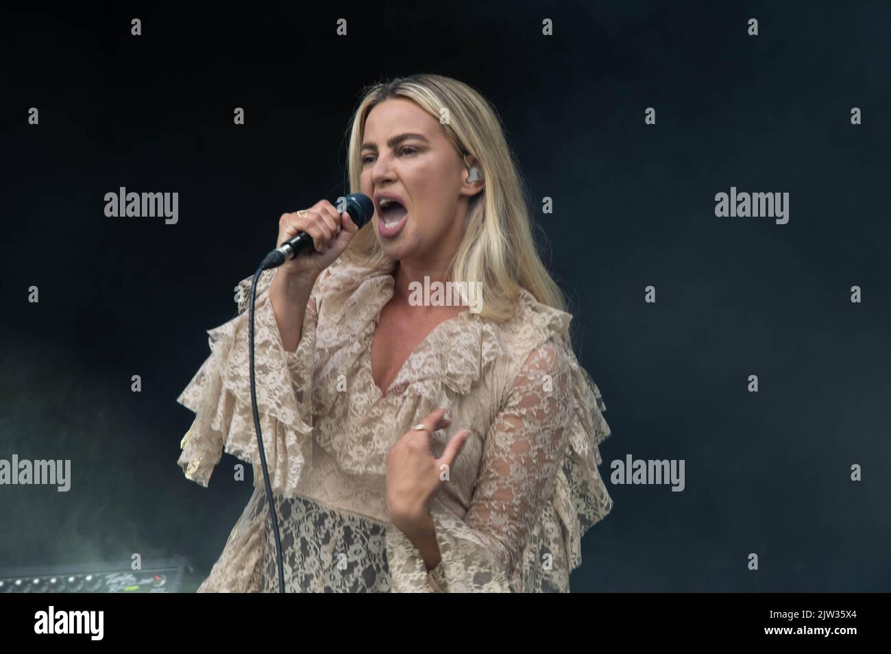 Lyra - singing to the connect audience wearing a lace thrilled blouse ...