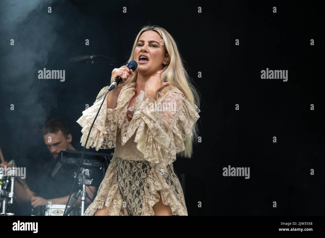 Lyra - singing to the connect audience wearing a lace thrilled blouse ...