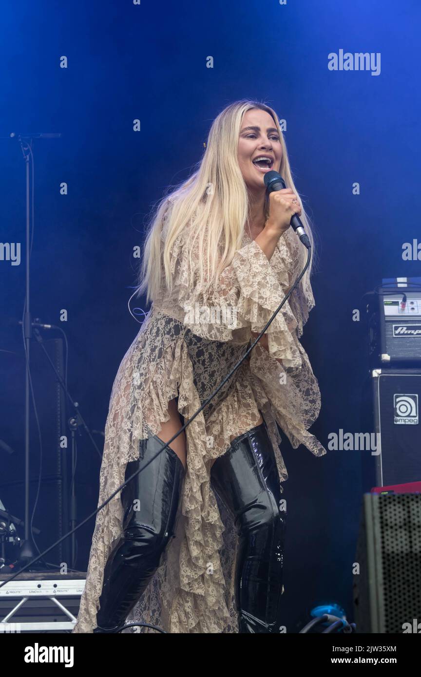 Lyra - singing to the connect audience wearing a lace thrilled blouse ...