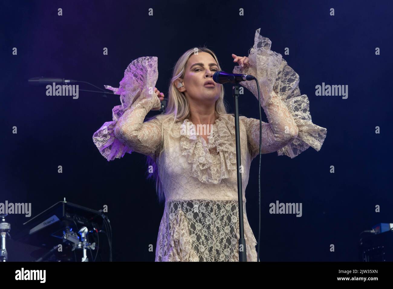 Lyra - singing to the connect audience wearing a lace thrilled blouse ...