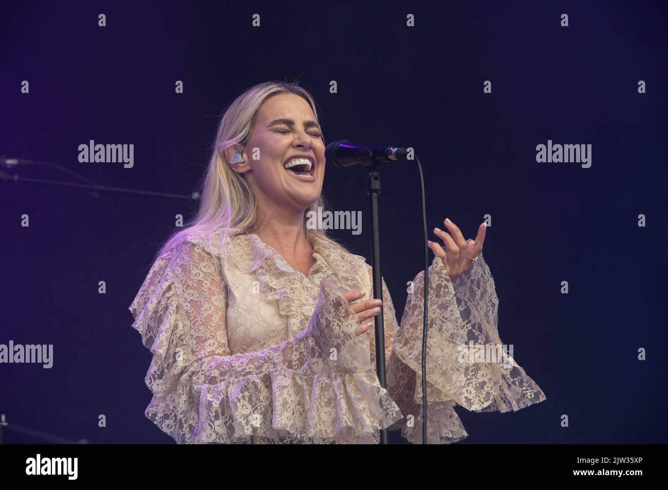 Lyra - singing to the connect audience wearing a lace thrilled blouse ...