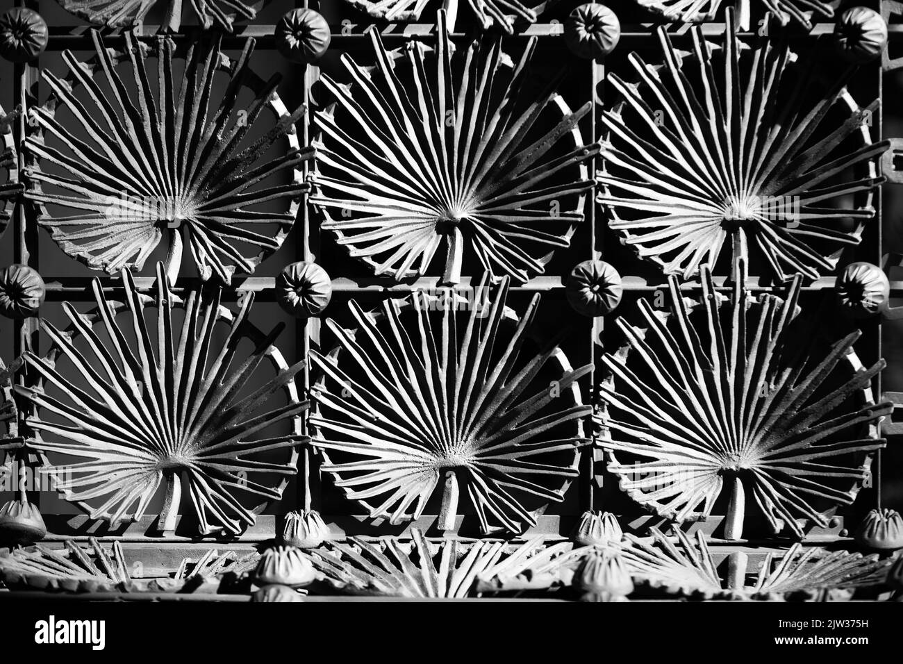 A grayscale shot of a metallic fence with abstract decorations Stock ...