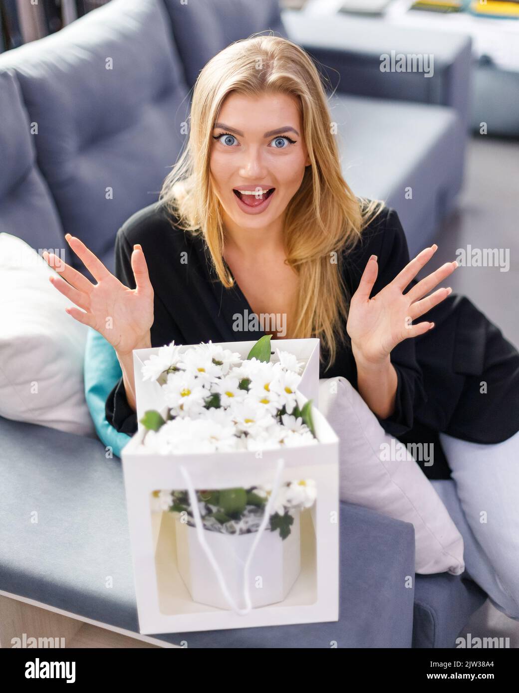 Happy excited woman is pleasantly surprised by bouquet of flowers ...