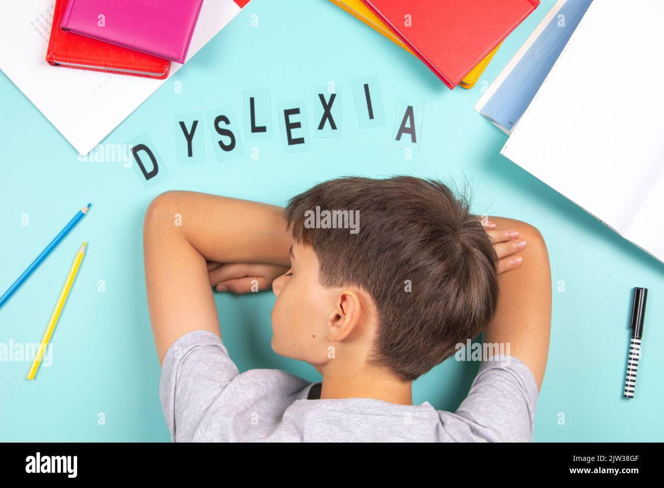 Sad tired frustrated boy lying on the table with many books. Word ...