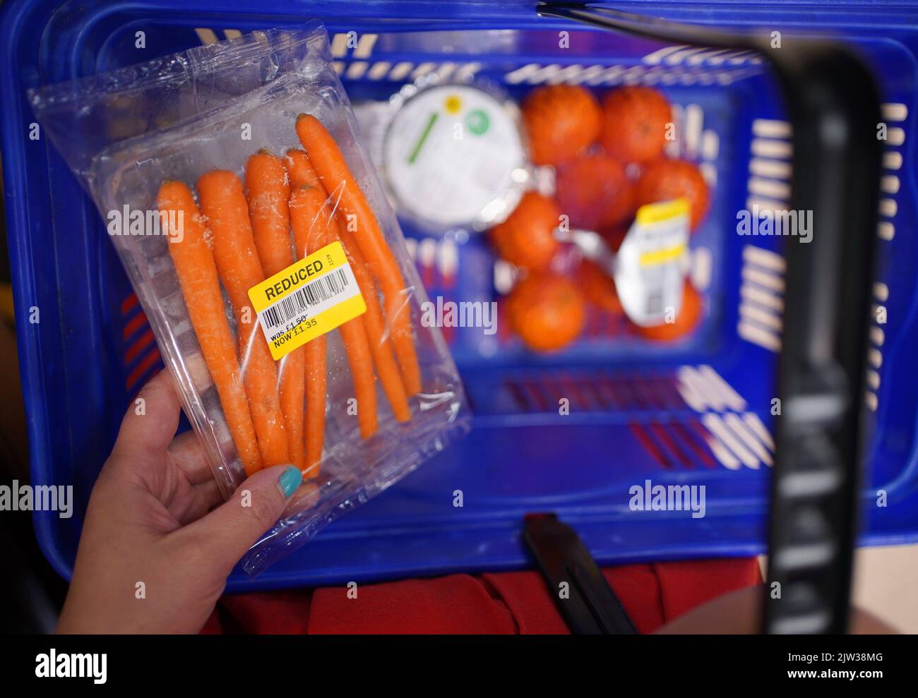 A shopper with a reduced item in a Tesco supermarket in London. Picture ...