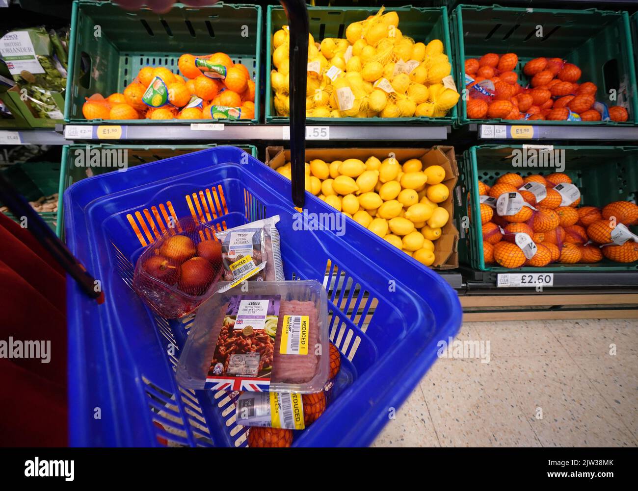 A shopper with reduced items in her basket, in a Tesco supermarket in ...