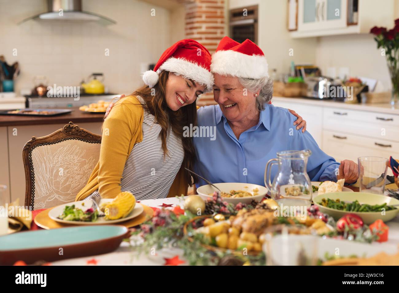 Senior caucasian woman and her adult daughter sitting at table for ...
