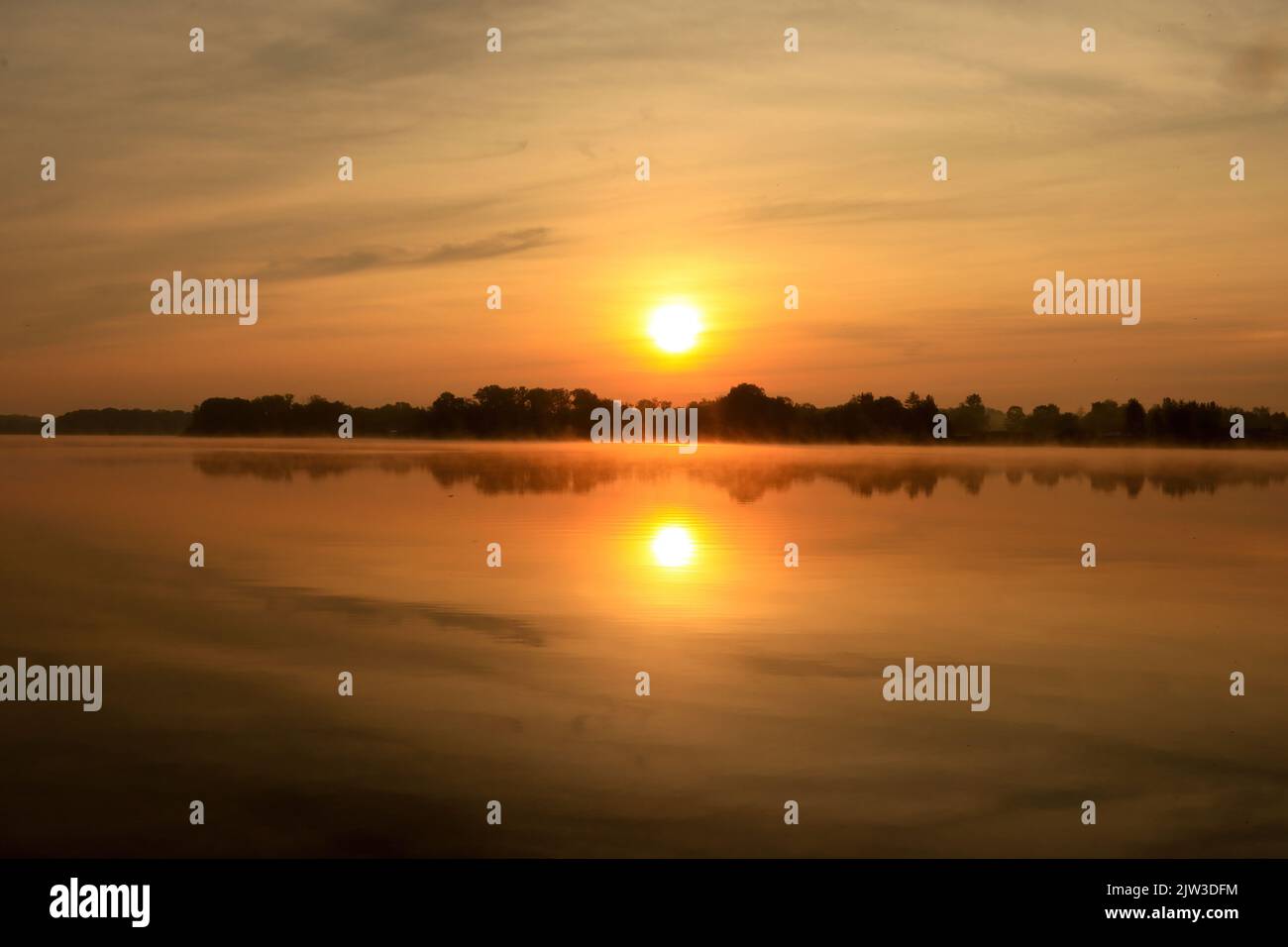 a beautiful golden sunset with symmetrical reflection in the sea Stock ...