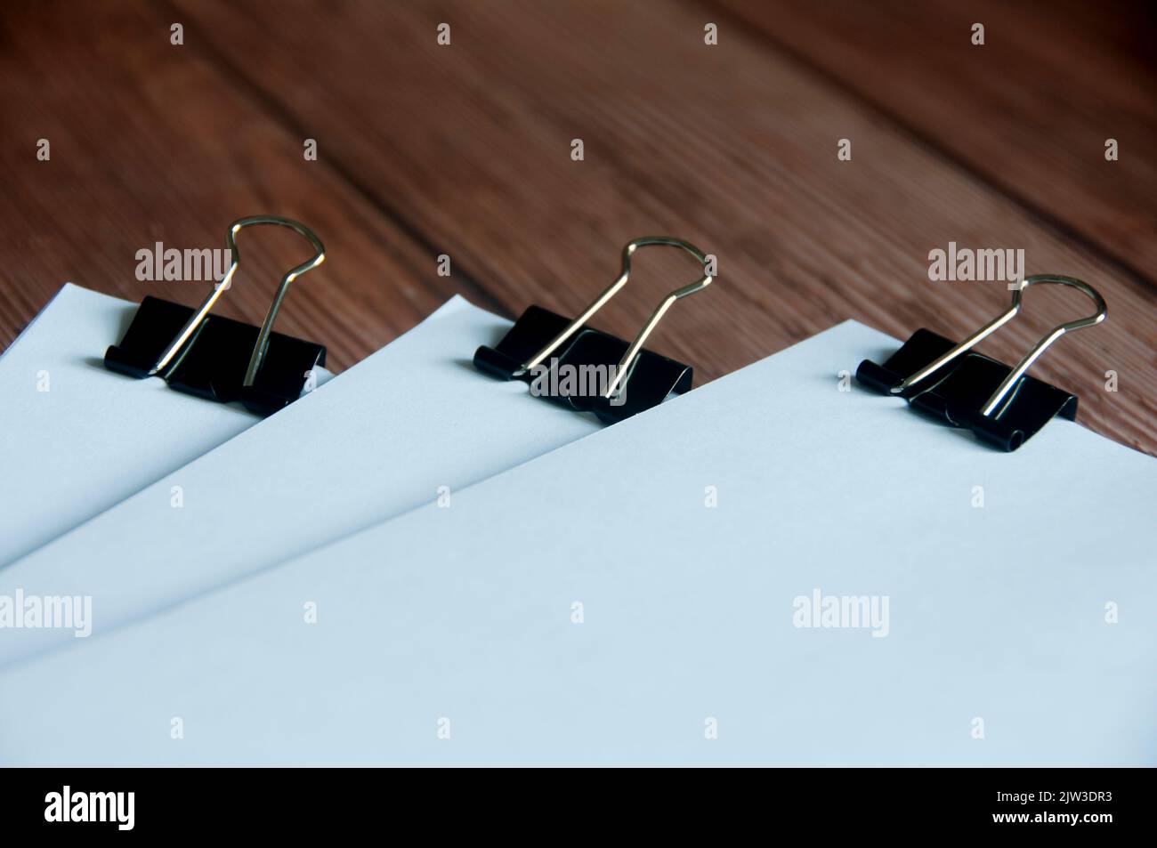 Paper stack of clipped pile of documents on wooden desk. Copy space and ...