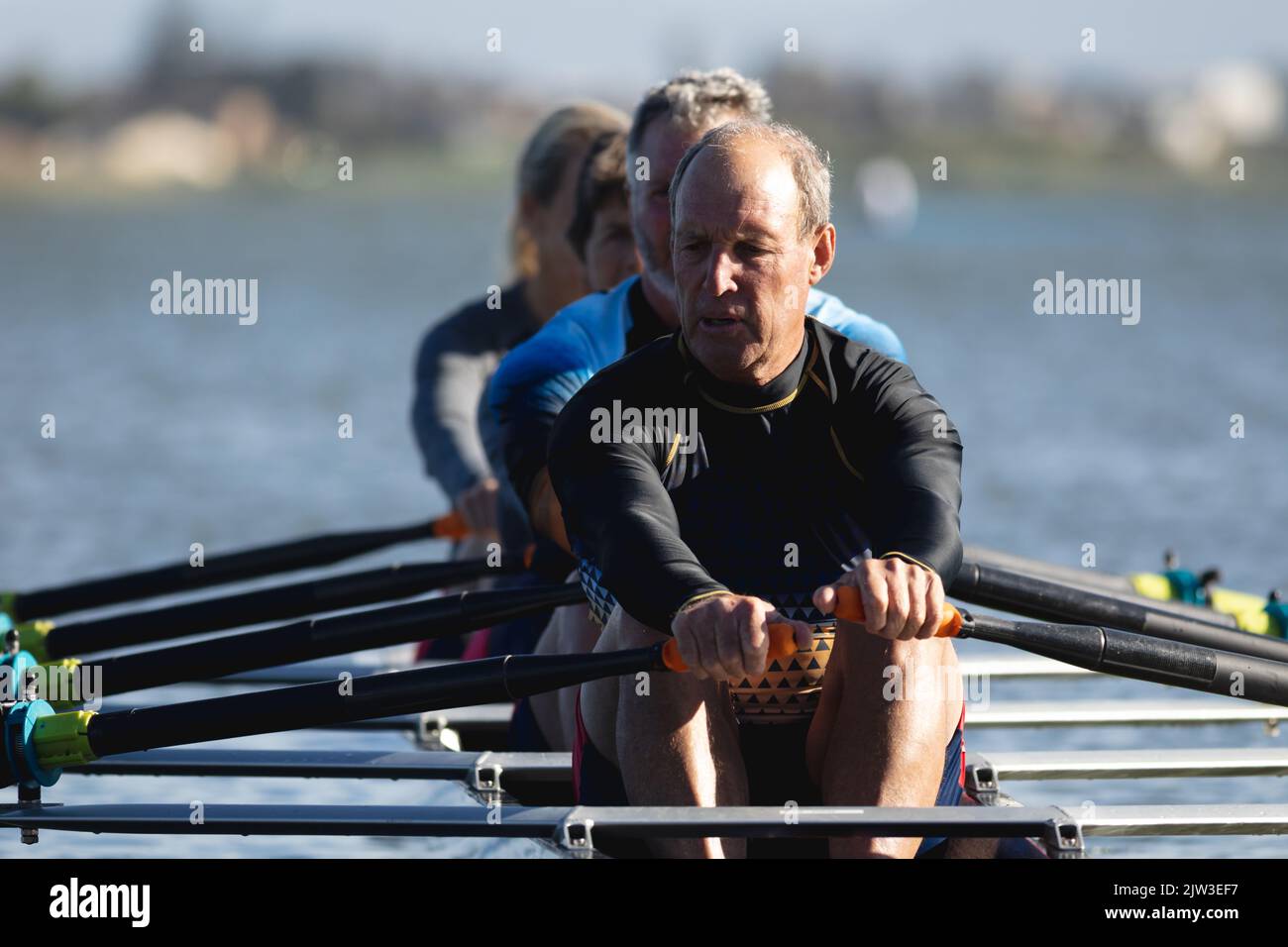 Senior caucasian rowing team rowing the boat on the lake Stock Photo ...