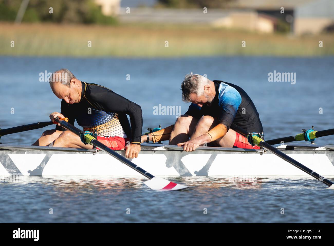 Two tired senior caucasian male rowers taking a break from rowing the ...