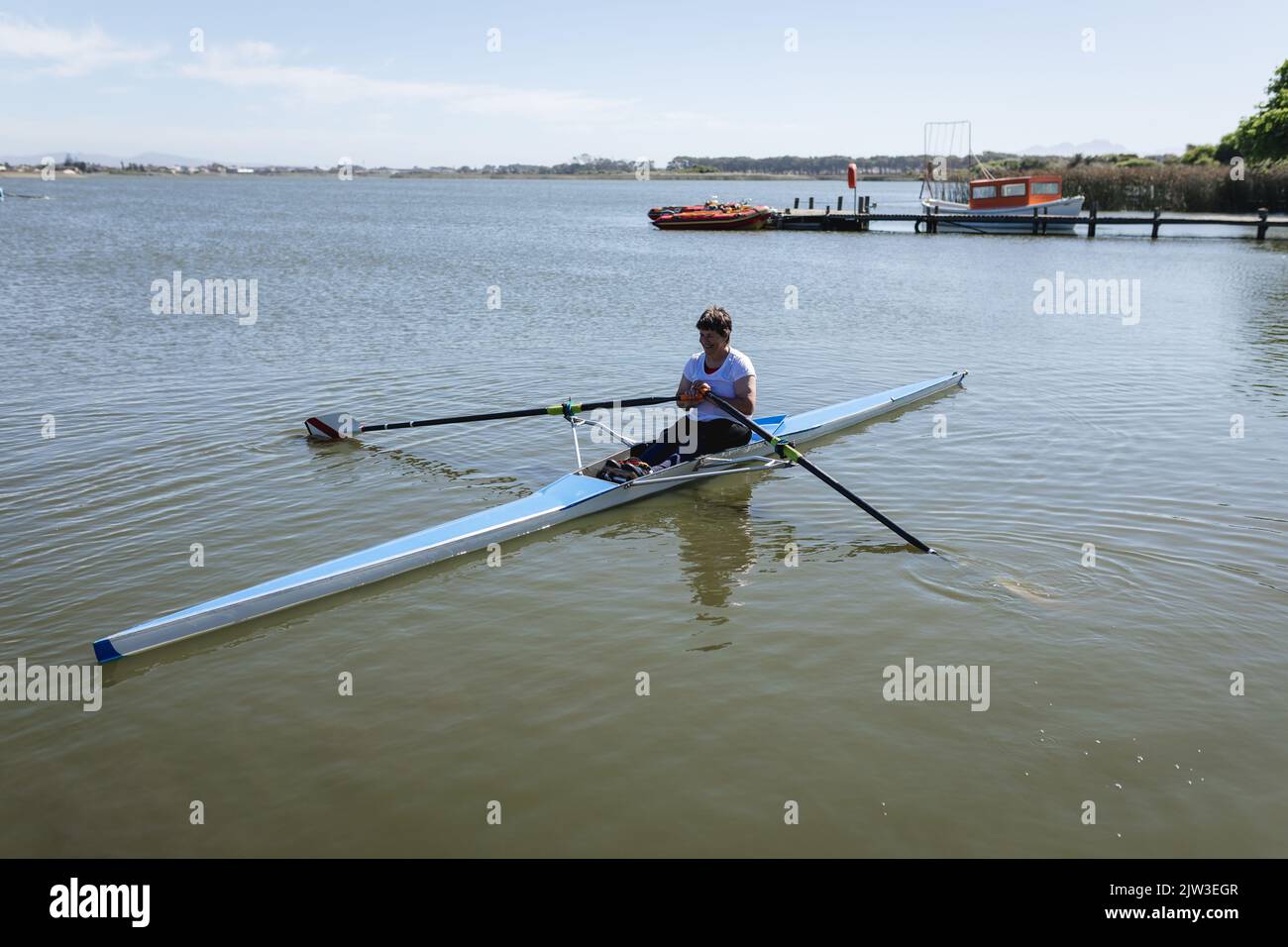 Senior caucasian rowing woman rowing the boat on the lake Stock Photo ...