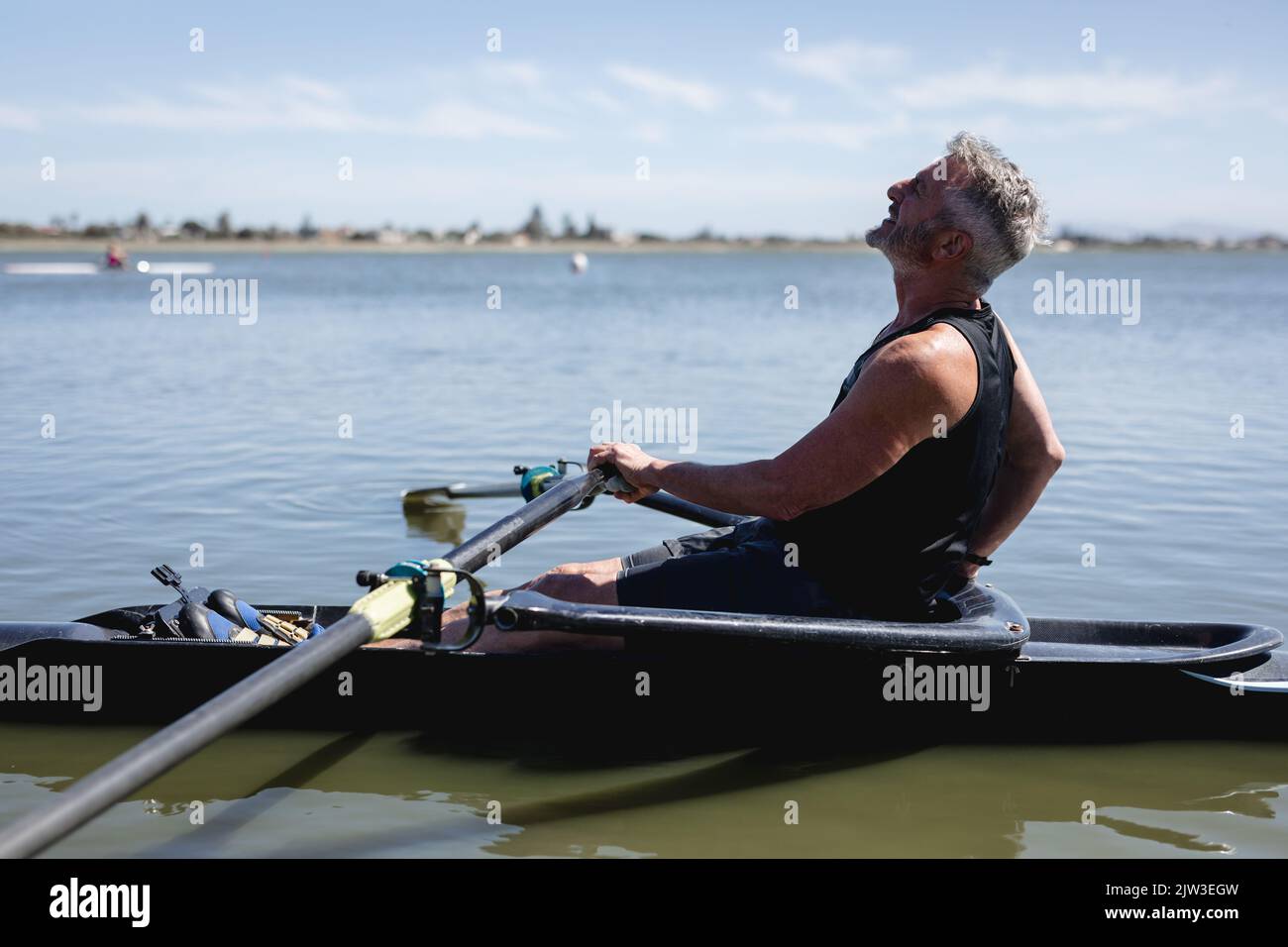 Senior caucasian male rower rowing the boat on the lake Stock Photo - Alamy