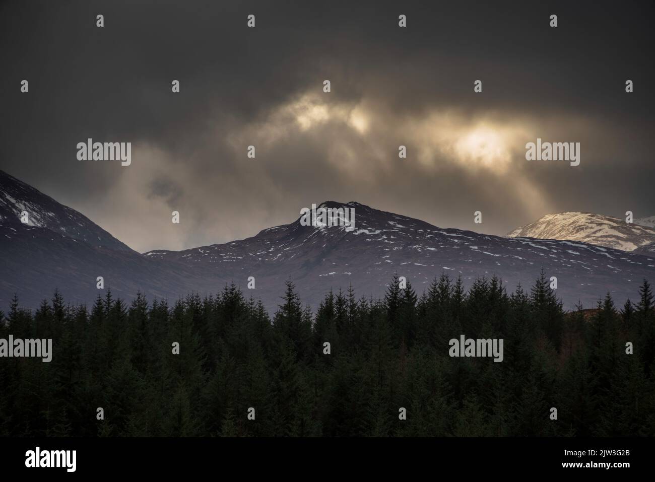 Landscape image of dramatic Winter storm sunset clouds over the peaks ...