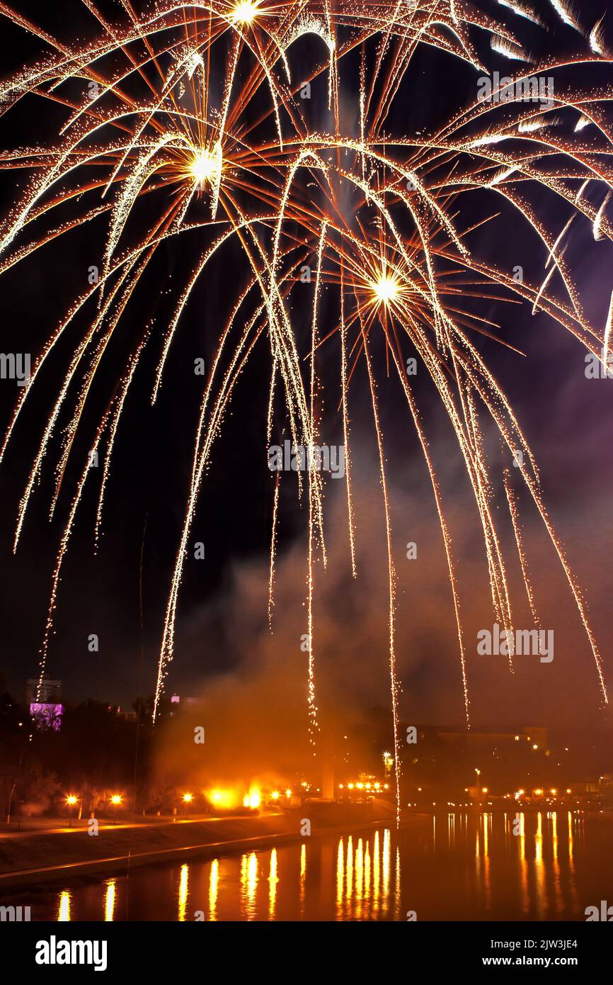 Flash of fireworks in night sky over river in city. Holiday concept ...