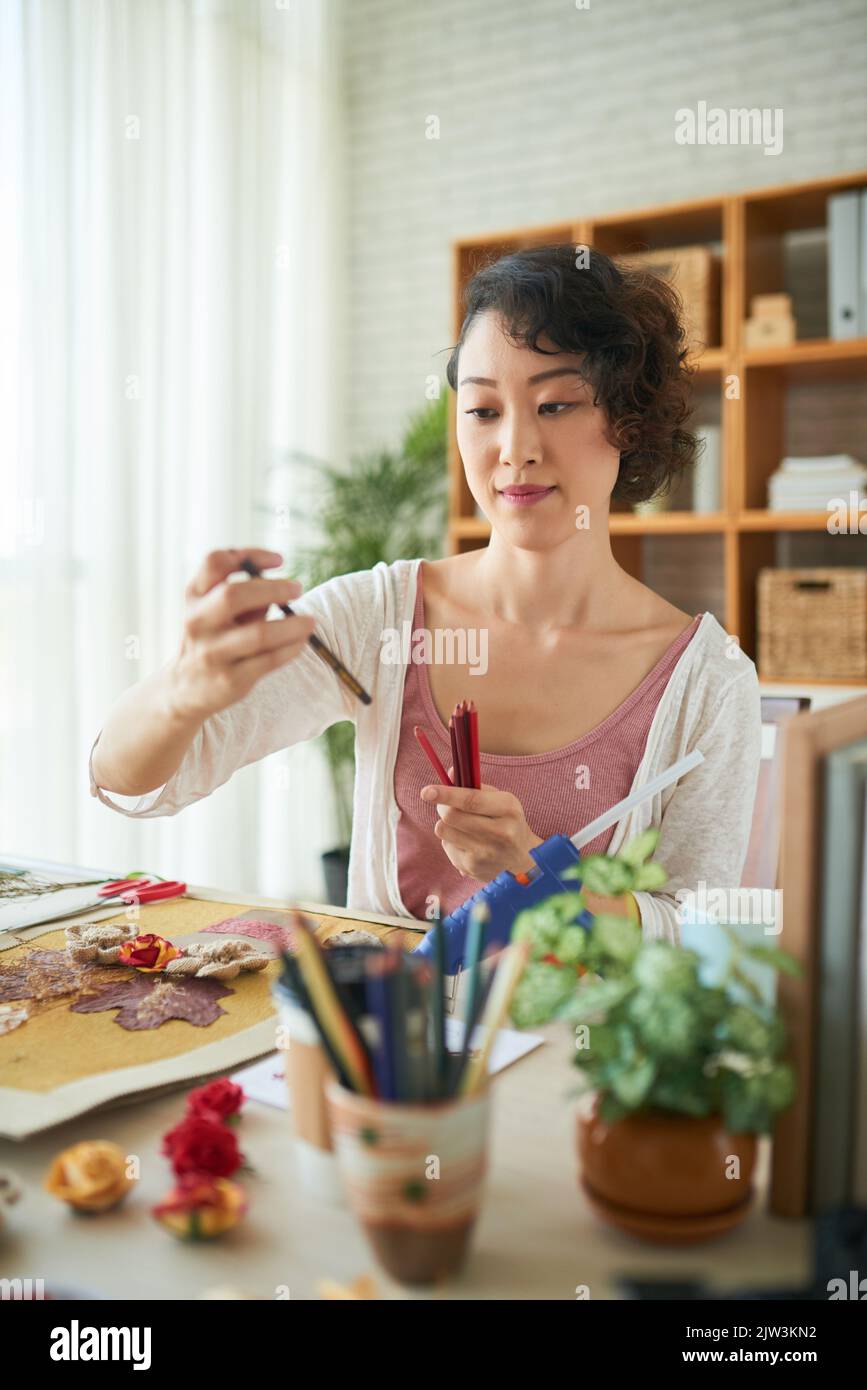 Young woman choosing color of pencil for drawing Stock Photo - Alamy