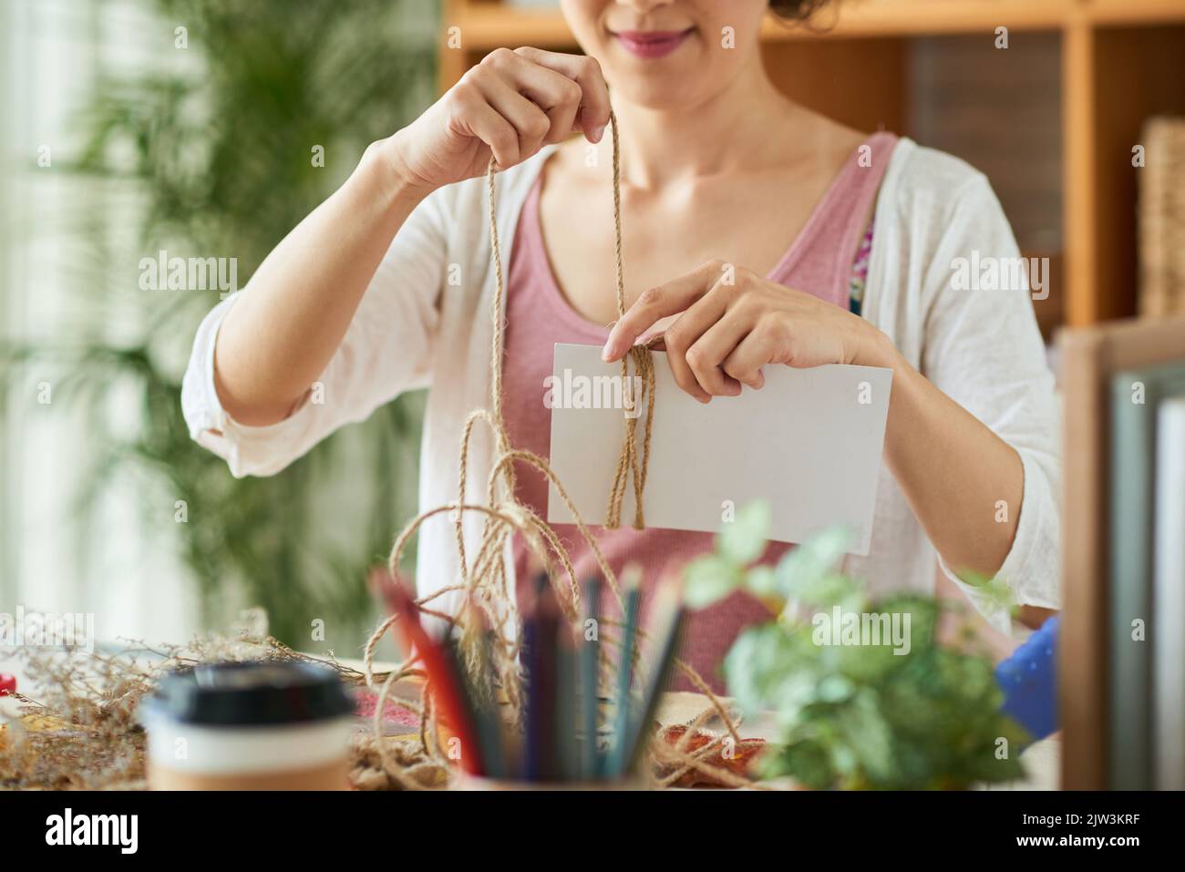 Creative woman wrapping string around cardboard rectangle Stock Photo ...