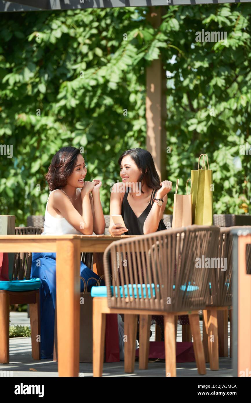 Joyful young pretty women sitting in outdoor cafe after shopping Stock ...