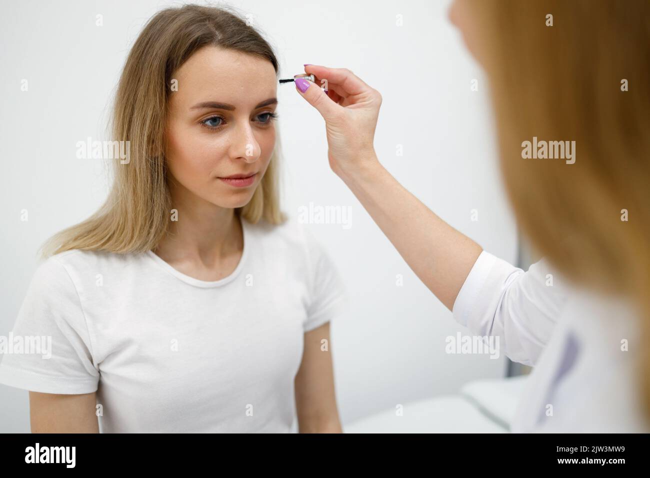 Doctor neurologist examining female patient. Checking the reflexes of ...