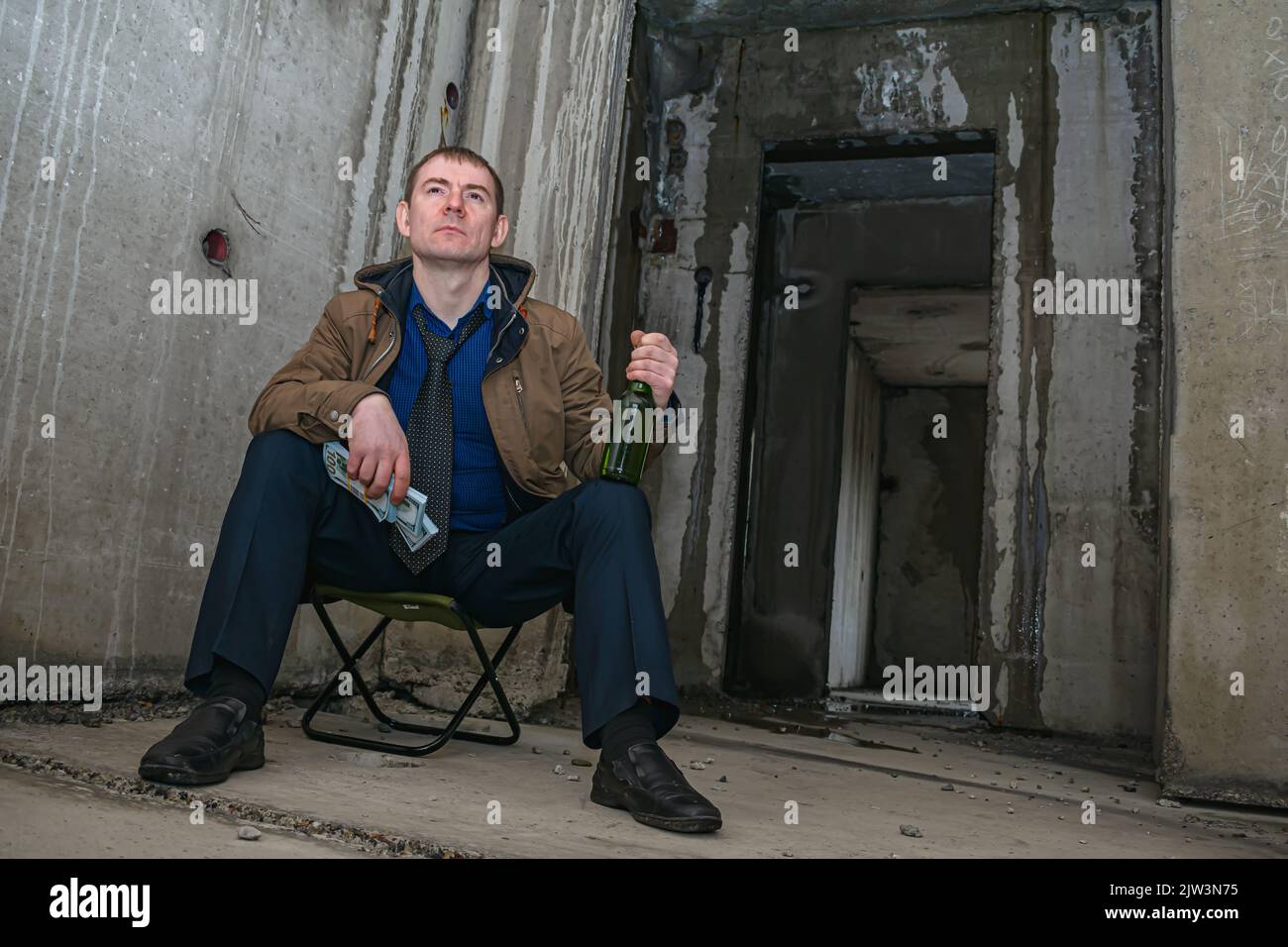 Ruined businessman in desperation gets drunk with alcohol in a ruined ...