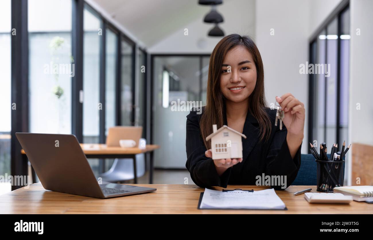 Real estate agent handing over keys house and model, rental and sell insurance concept Stock ...