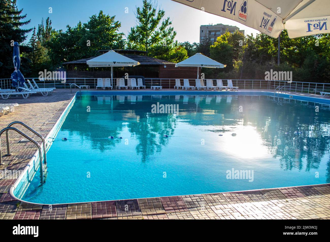 Primorsk, Ukraine. Poolside. Sunbeds near swimming pool surrounded by ...