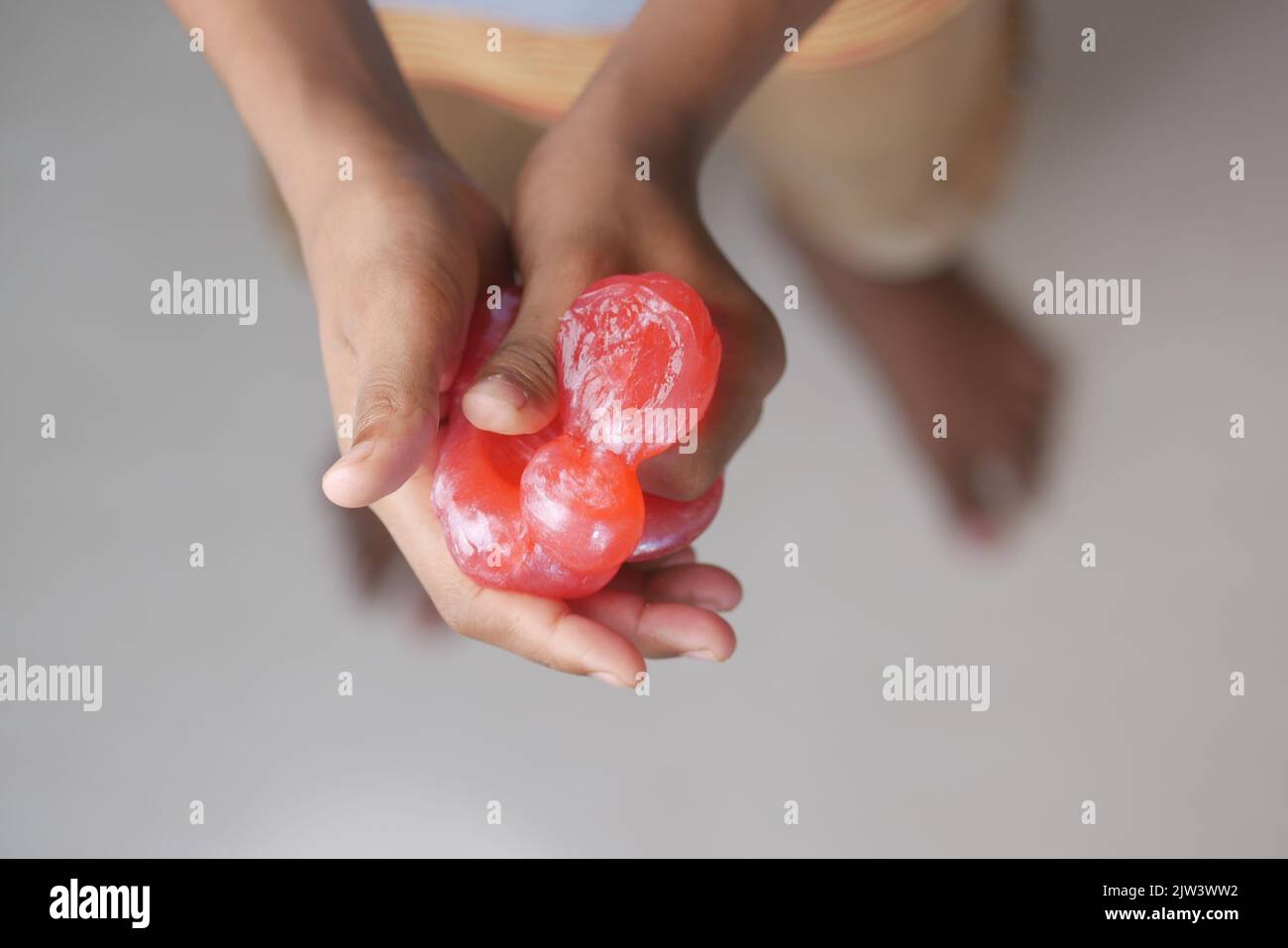 child Hand holding pink color slime Stock Photo - Alamy