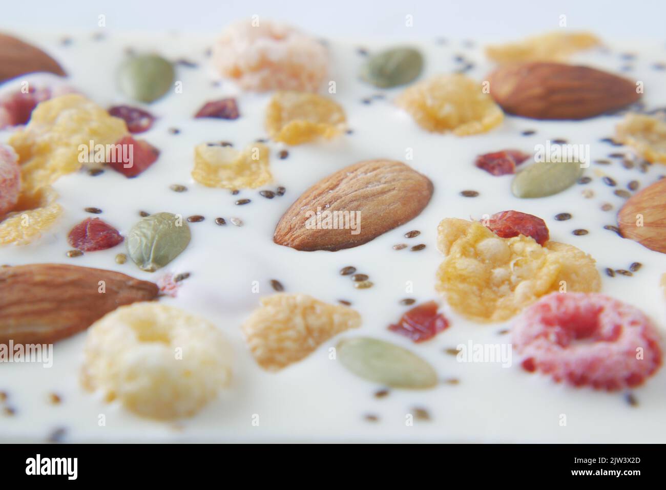 Nut candy in white chocolate on white backgorund Stock Photo - Alamy