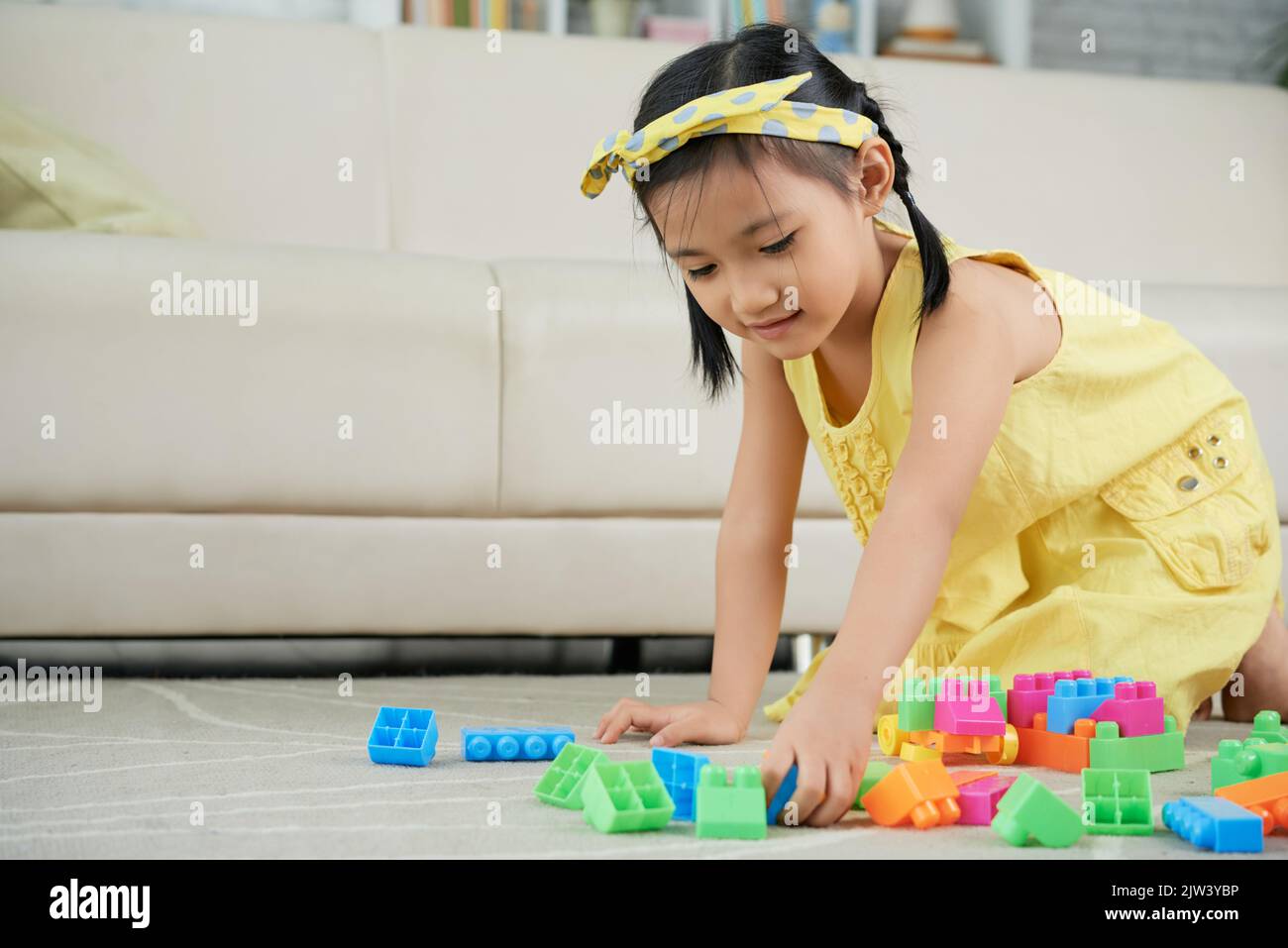 Adorable little girl playing with plastic cubes Stock Photo - Alamy