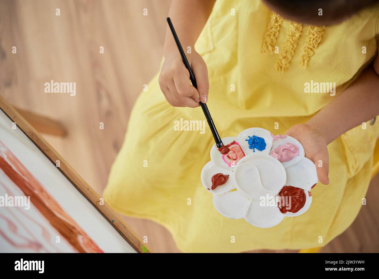 Girl mixing colors in pallette when painting Stock Photo - Alamy