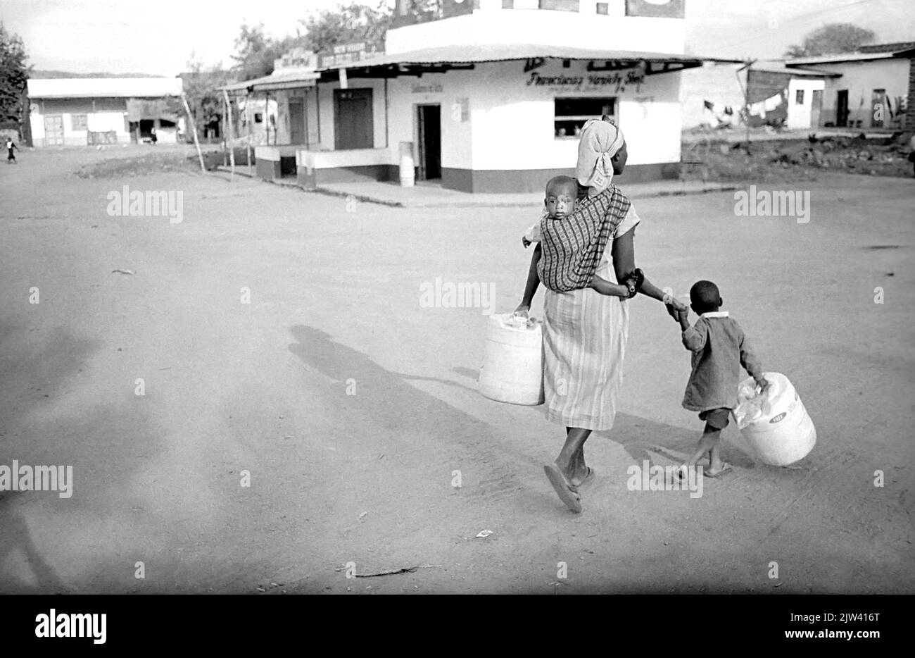 A woman and a child carrying water jerrycans and look for the river ...