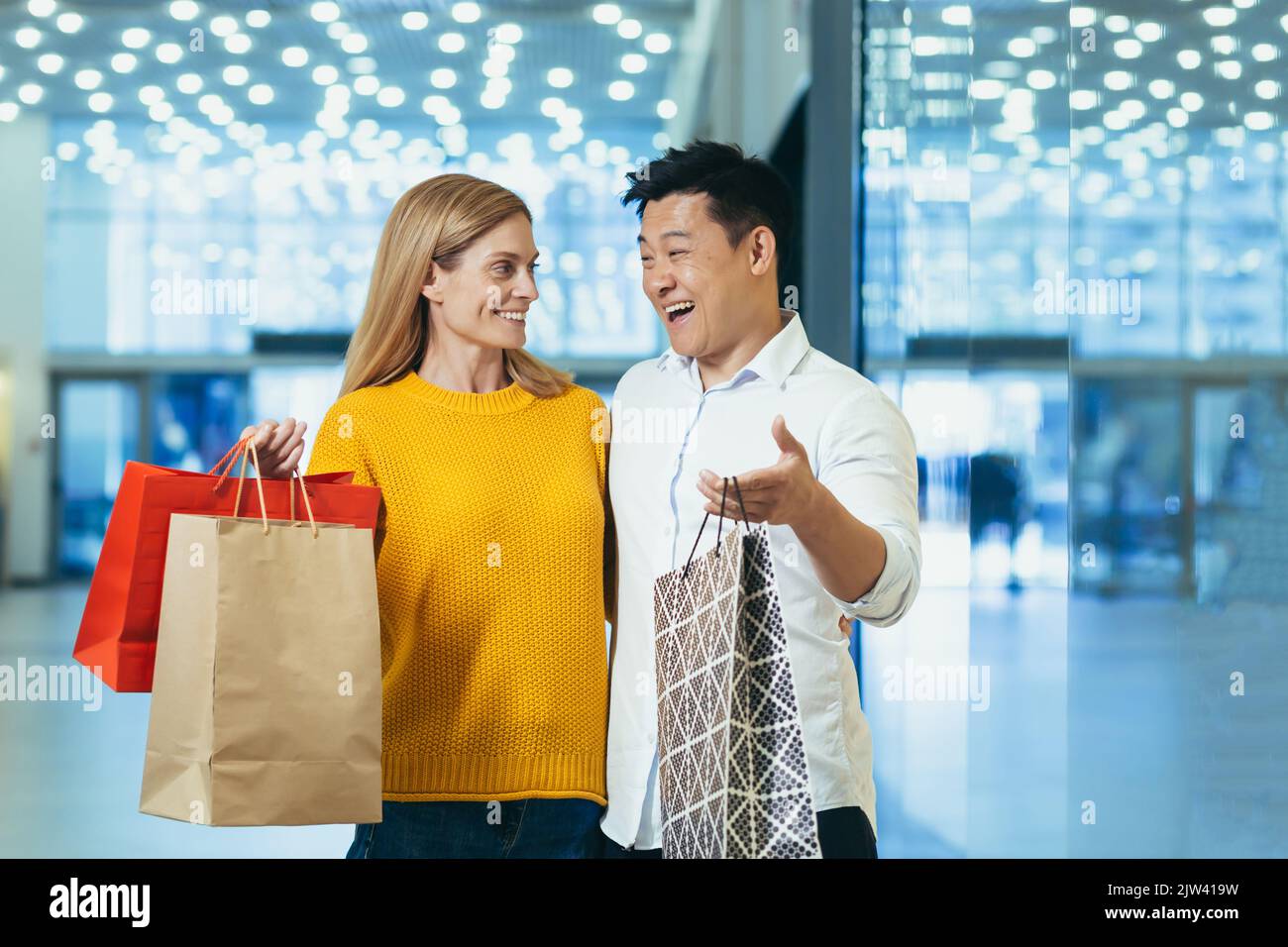 Young happy married couple shoppers man and woman in the supermarket ...