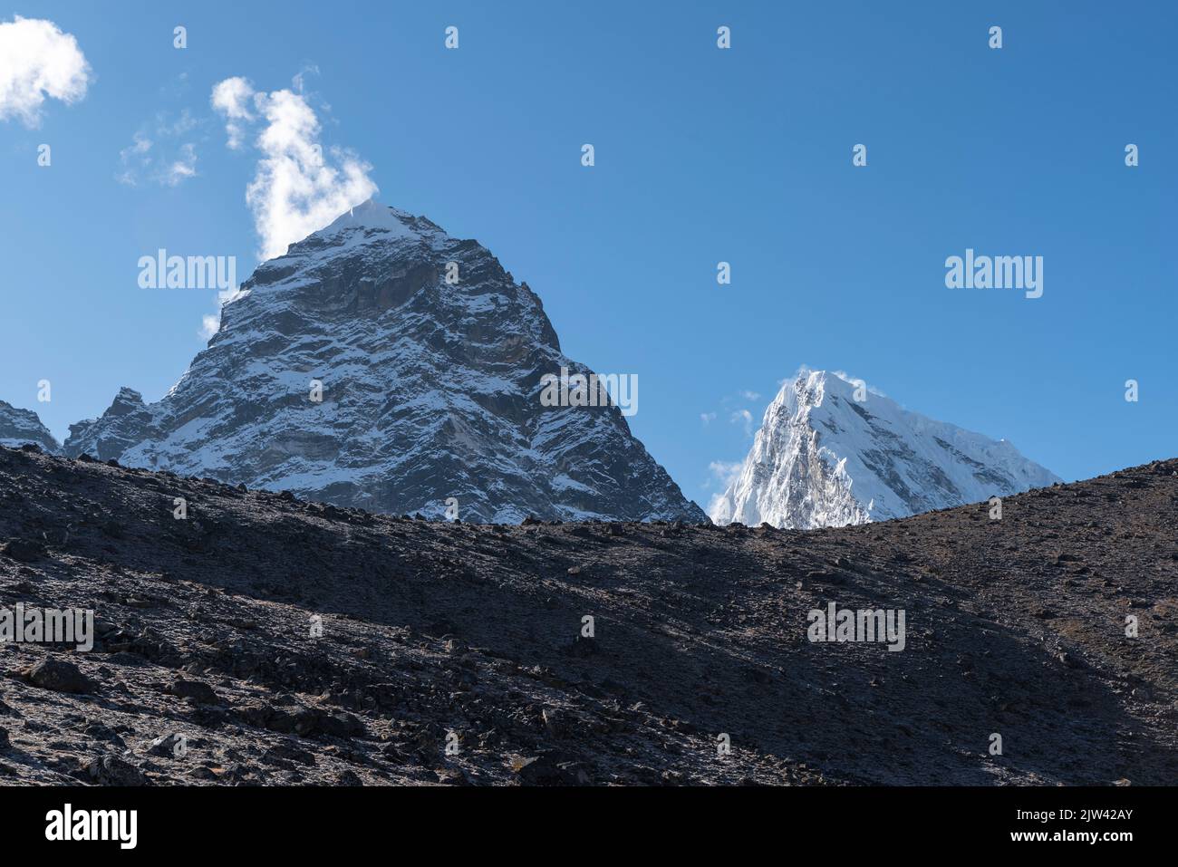 A low angle shot of snowy sharp mountains under a blue sky Stock Photo ...