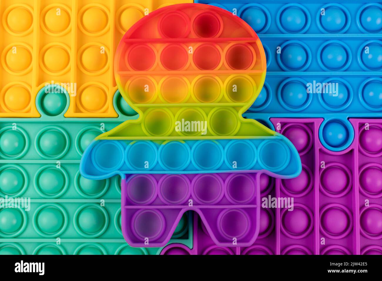 Colorful fidget toy POP IT of human shape on puzzle background. Sensory ...