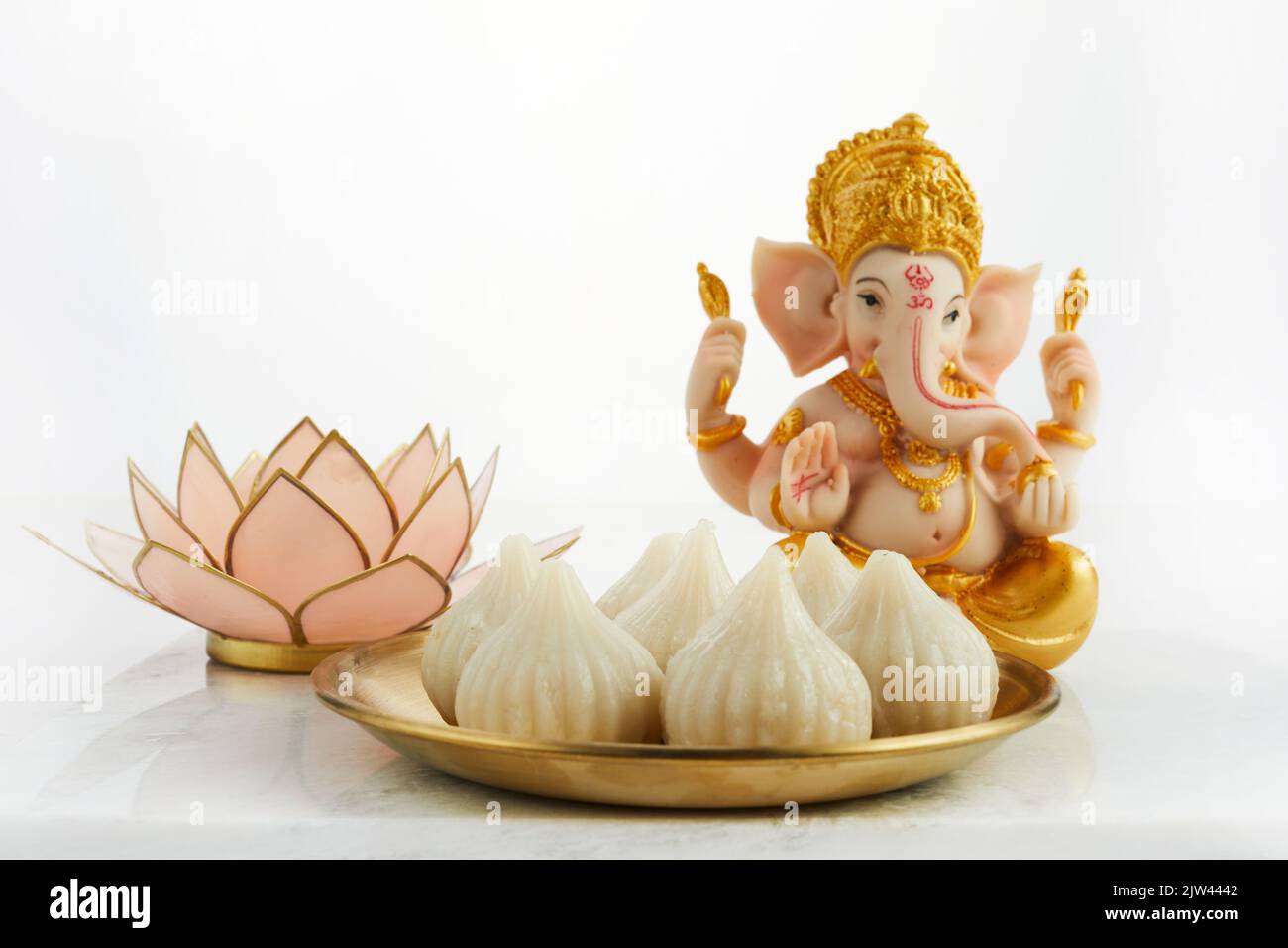 Idol of lord Ganesha with Modak Sweet Dish and flower. Ganesh chaturthi ...