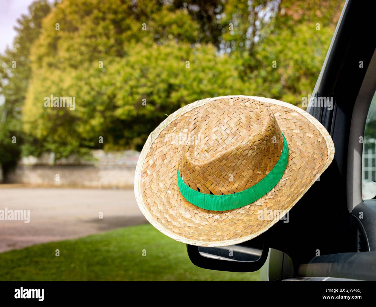 straw hat placed on the rear view mirror of a vehicle in the ...