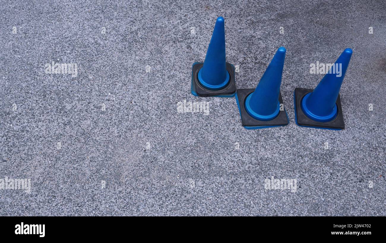 Blue color plastic material traffic cones and old grey color textured ...
