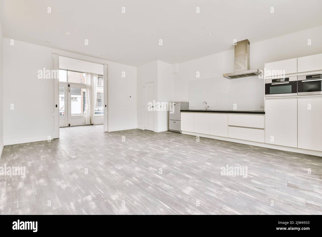 Interior of empty white kitchen with windows and wooden parquet floor ...