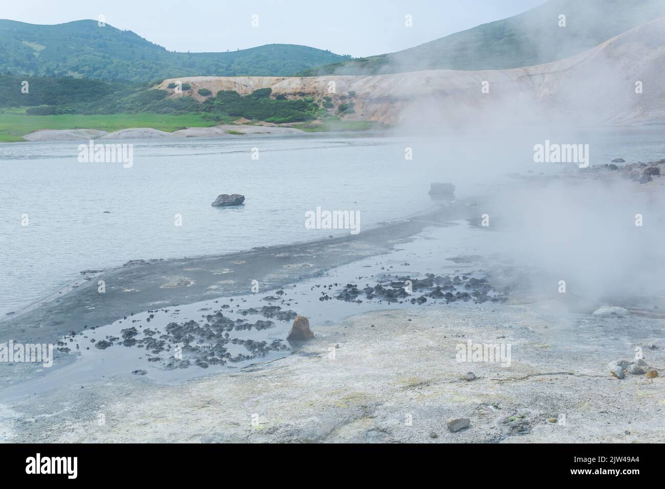 steaming hydrothermal outlet on the shore of the hot lake in the ...
