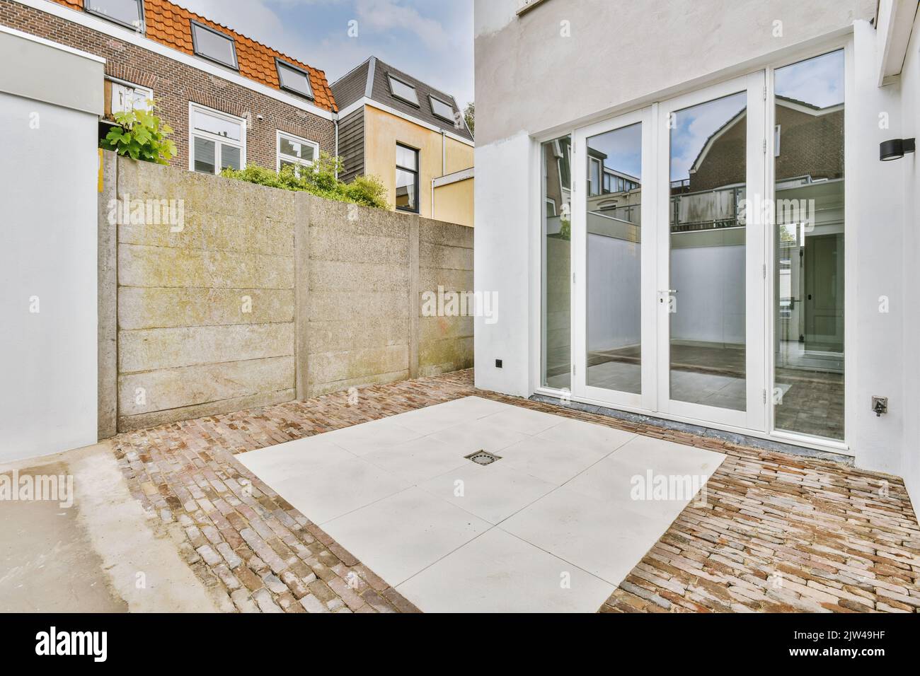 Neat paved patio near fence Stock Photo - Alamy