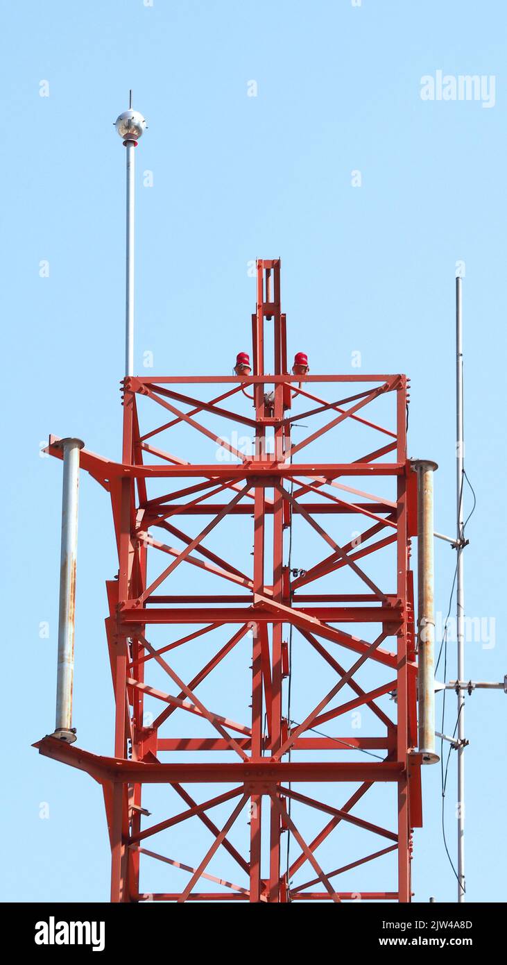 Telecom tower closeup with red color and blue sky Stock Photo - Alamy