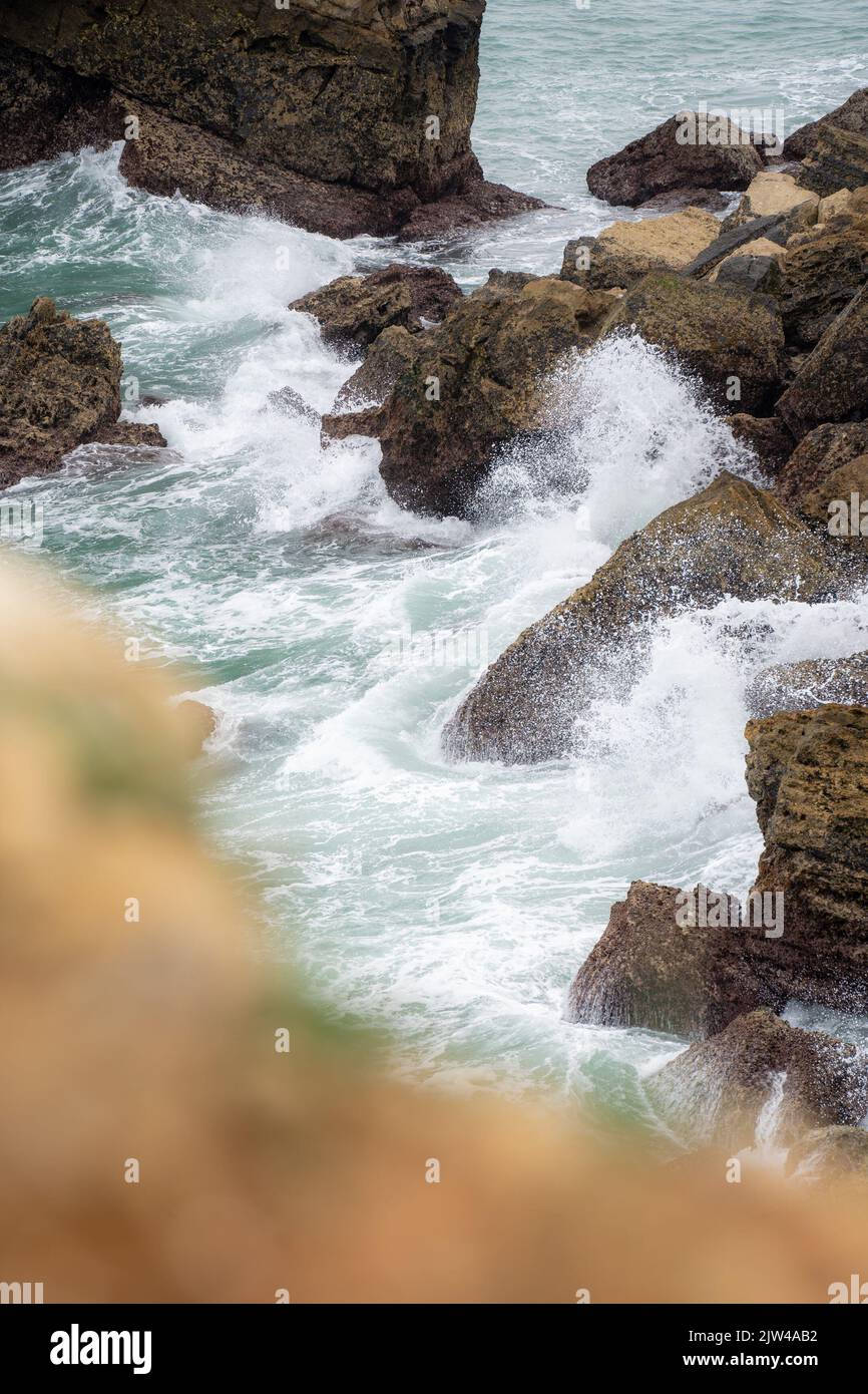 A vertical of foamy waves hitting sea stacks Stock Photo - Alamy