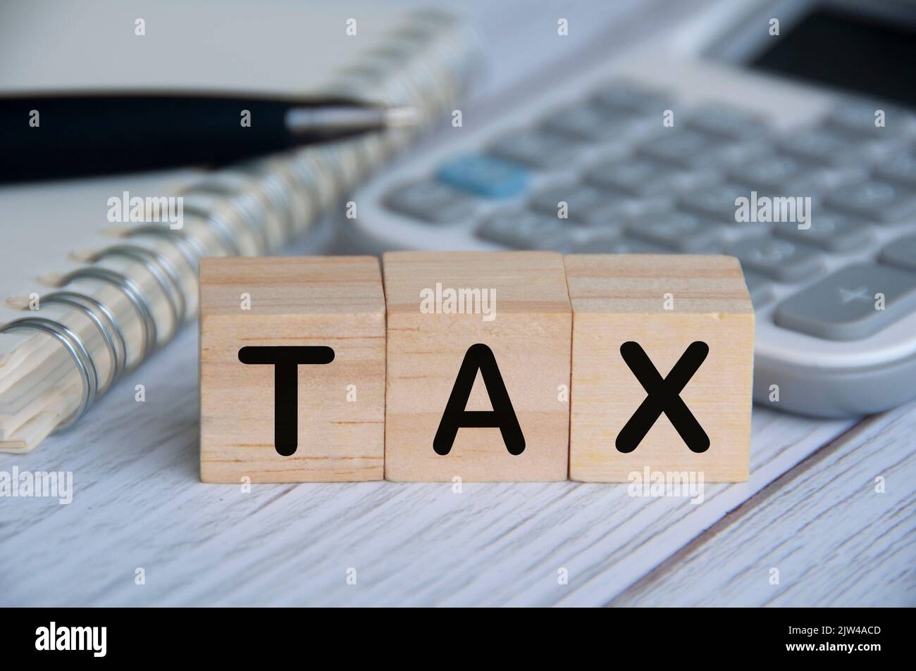 Tax word on wooden blocks with calculator, notebook and pen background ...