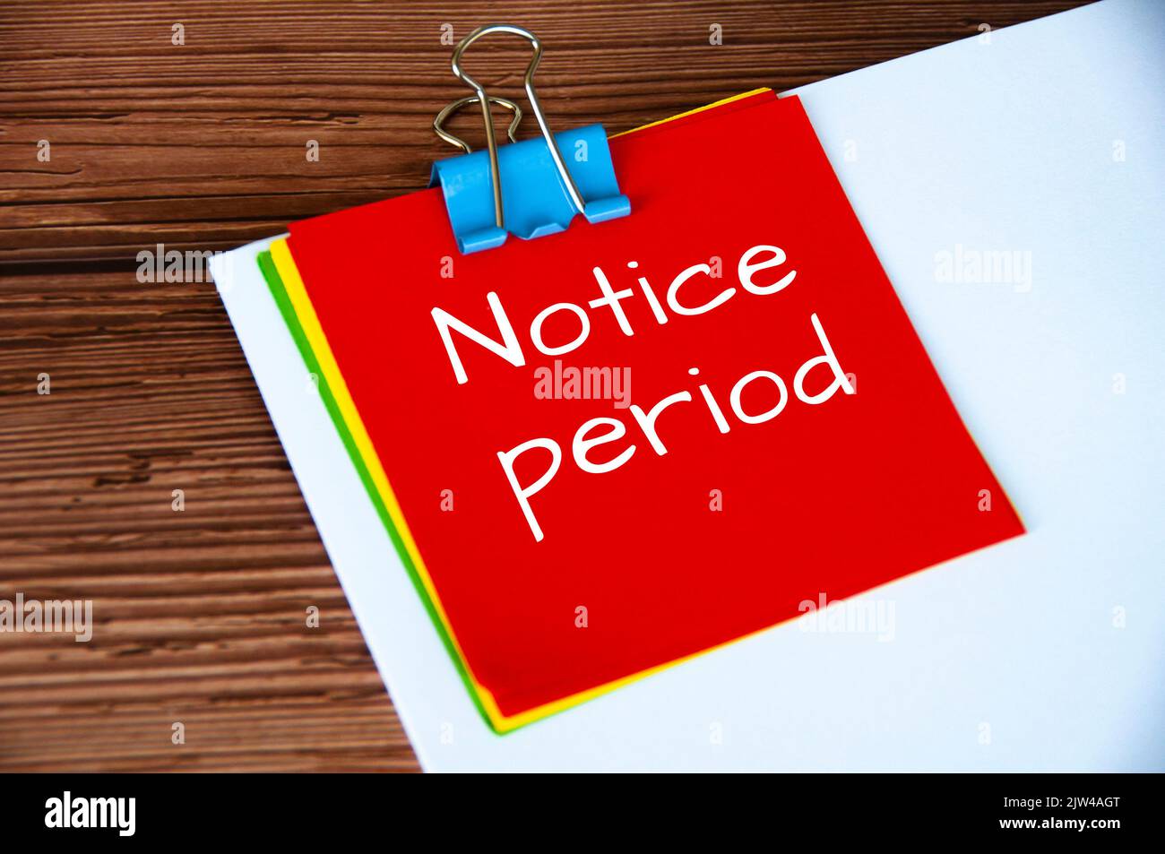 Notice period text on red notepad wooden desk background. Resignation ...
