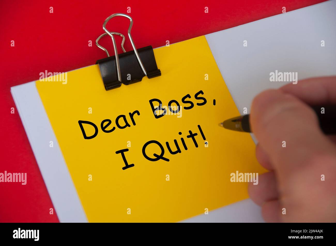 Dear boss, I quit text on yellow notepad on red cover background ...