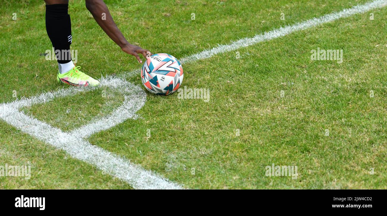 A football player places the ball outside the quadrant at a corner in a ...