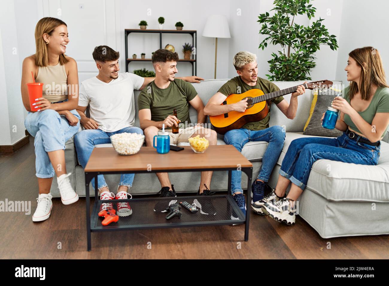 Group of young friends on party smiling happy and playing classical ...