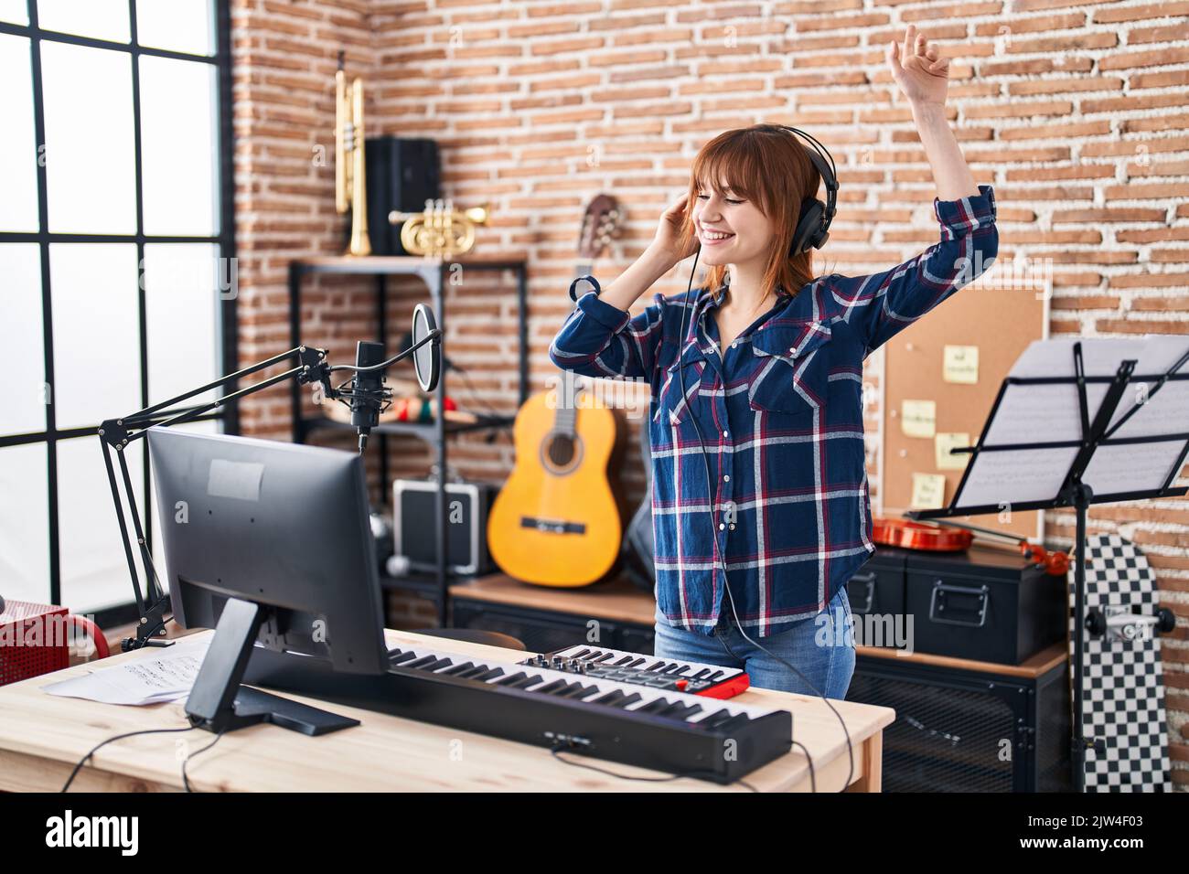 Young woman musician playing piano keyboard at music studio Stock Photo ...