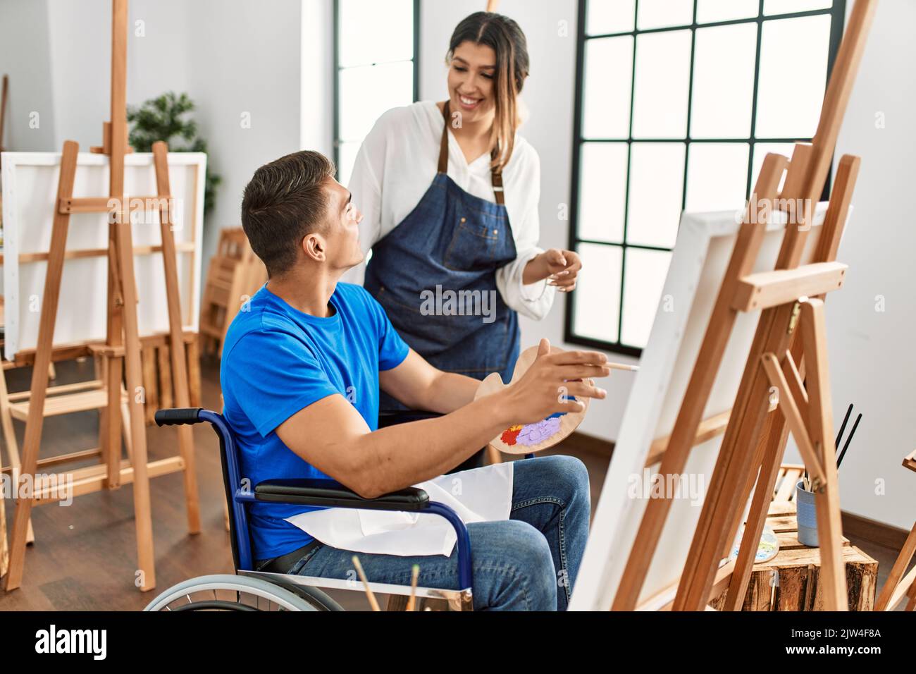 Teacher and disabled paint student sitting on wheelchair smiling happy ...