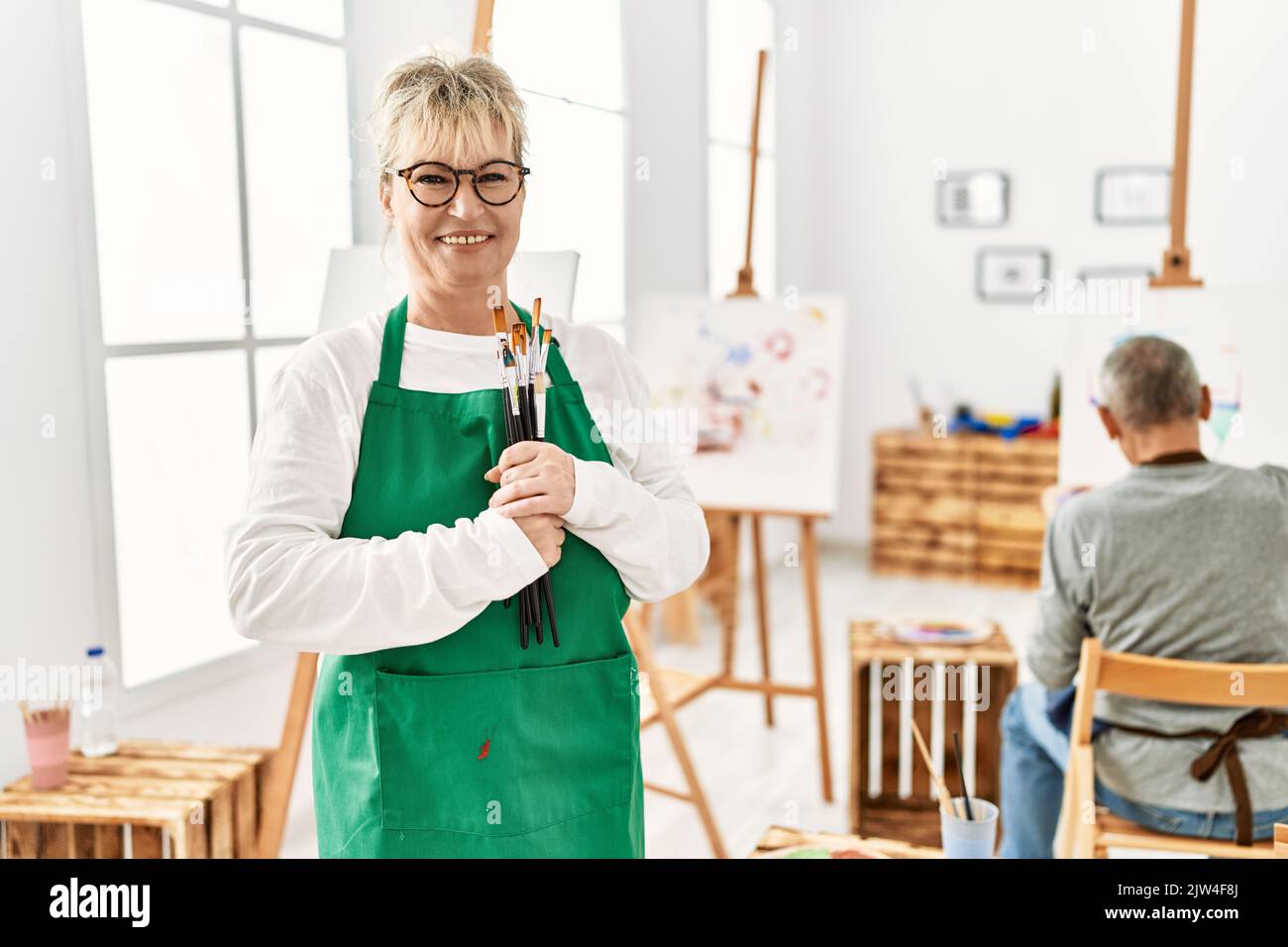 Two senior paint student smiling happy painting at art studio. Woman ...